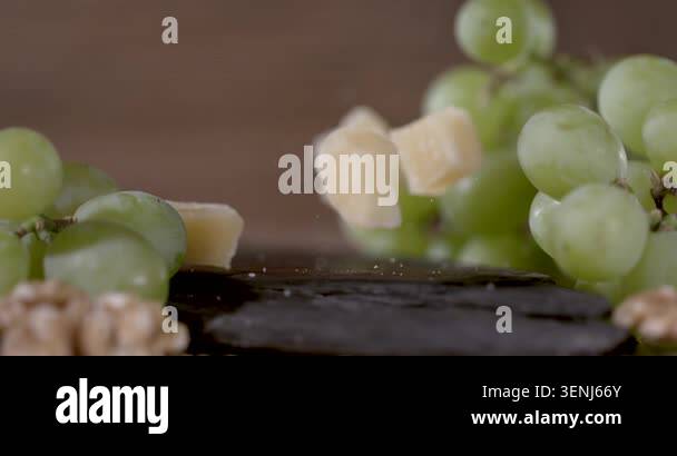 Super Slow Motion Cheese Cubes Cascading Onto Slate Near Grapes Stock ...
