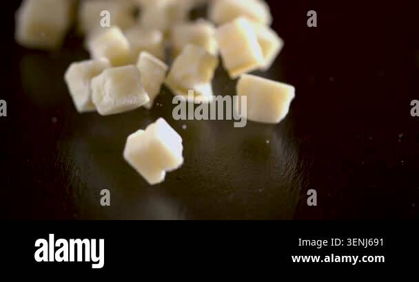Super Slow Motion Cheese Cubes Falling Closeup On Glossy Black Stock ...