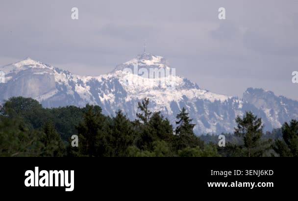 Snowy Mountain Peak Over Evergreen Forest Under Moody Overcast Sky ...