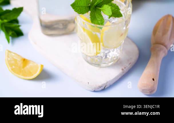 Lemon infused water with mint in glass beside bottle, healthy hydration ...