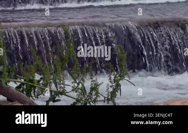 Close up view of rushing water cascading smoothly over a concrete ...