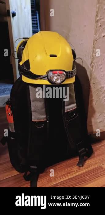 Work backpack with yellow safety helmet, hearing protection and work ...