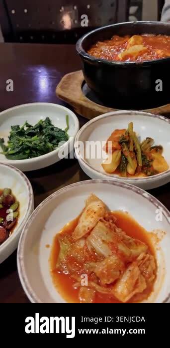 Moving shot across Korean dining table with assorted banchan side ...