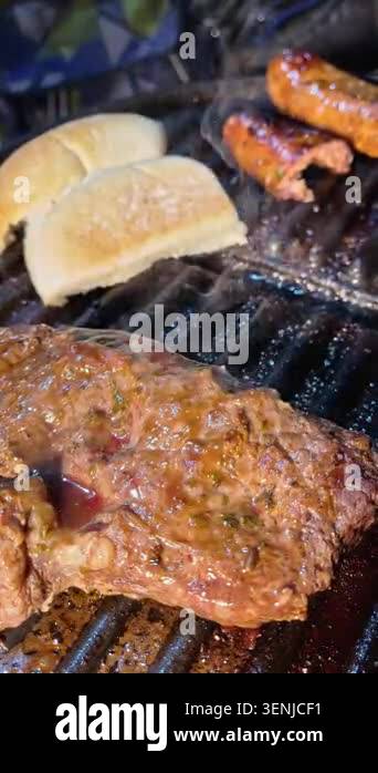 Close up panning shot of juicy grilled steak on hot barbecue with ...
