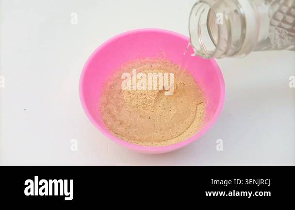 Traditional Ayurvedic Ubtan Powder Mixing Process in Pink Plastic Bowl ...