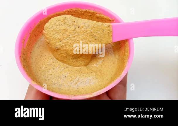 Traditional Ayurvedic Ubtan Powder Mixing Process in Pink Plastic Bowl ...