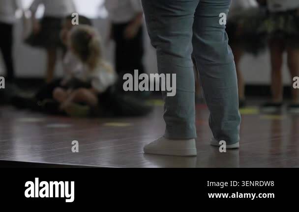 Womans legs dancing on stage during a rehearsal with blurred children ...