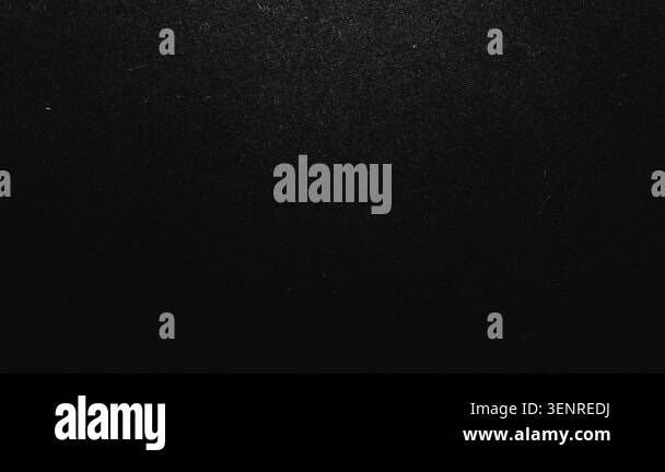 macro texture of black denim fabric slowly moving under dramatic moody ...