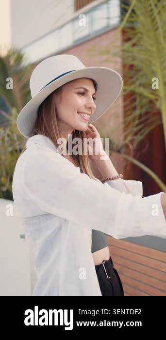 A beautiful woman smiles while wearing a stylish hat and white shirt ...