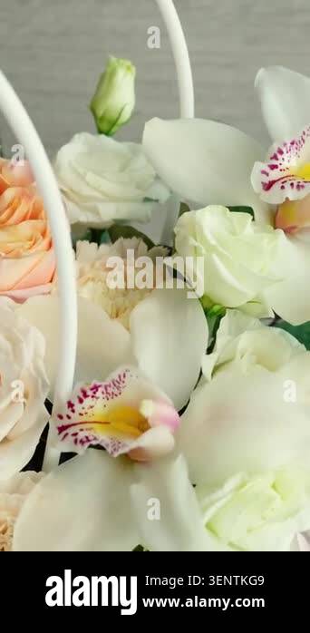 A beautiful romantic bouquet of unusual white roses in a handbag. A ...