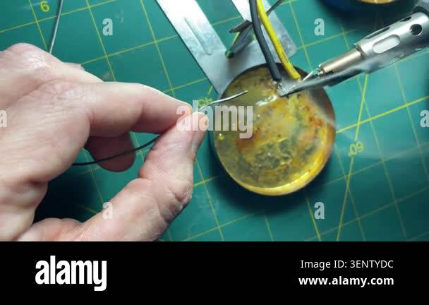 Close up footage of a person using a cordless gas soldering iron to ...