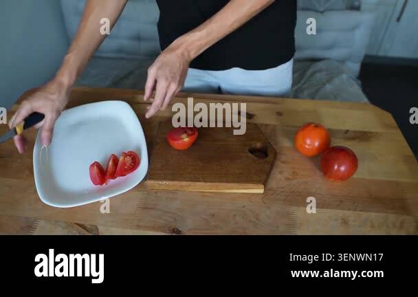 Close up footage of a person cutting and serving ripe red tomato in a ...