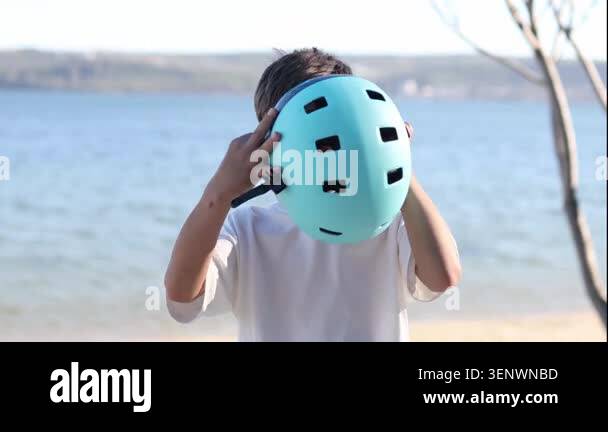Young boy putting on a protective helmet before a bike ride near the ...