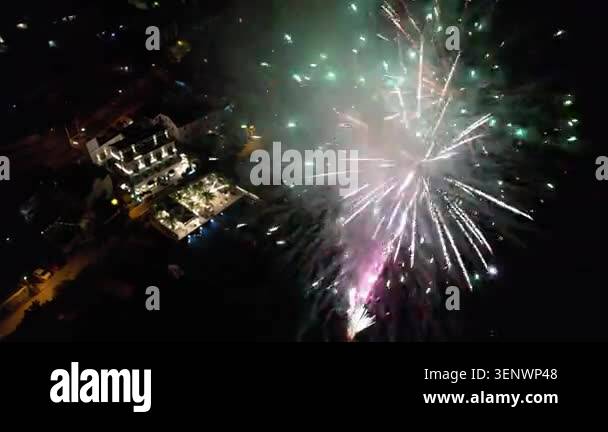 Aerial green fireworks burst over waterfront, intense neongreen ...