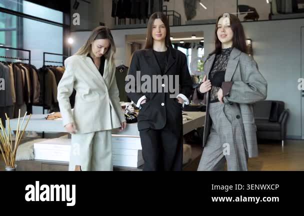 Women trying on stylish business suits and blazers at a fashion ...