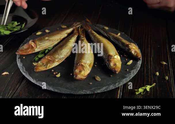 Person with hands holding tweezers carefully places fresh herbs on a ...