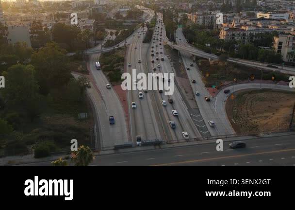 Los Angeles highway interchange during golden hour sunset with traffic ...