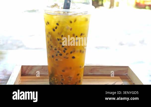 Iced passion fruit juice with pulp and seeds in a plastic cup Stock ...