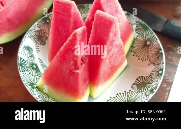 Freshly cut watermelon slices on a plate with knife and fruit ...