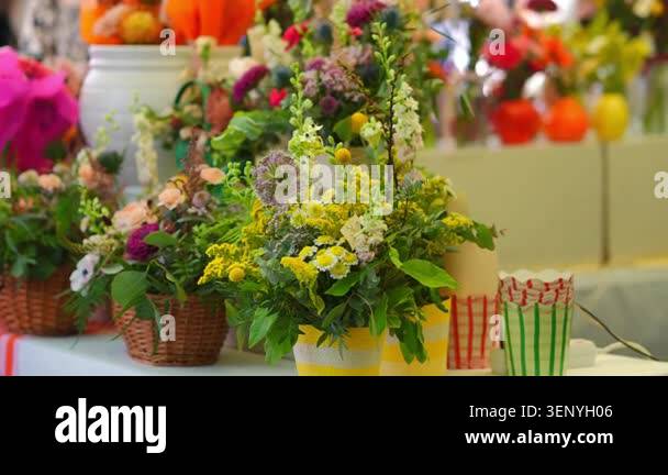 Colorful flower arrangements and bouquets sitting on a stall at a ...