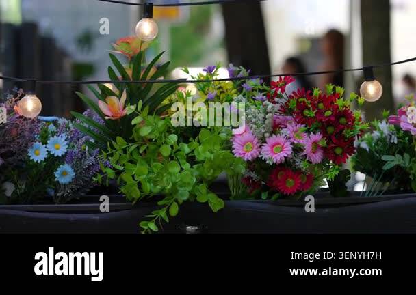 Beautiful assortment of colorful artificial flowers in a dark planter ...