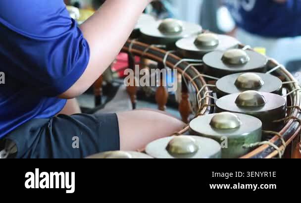 Hands playing traditional Thai gong circle instrument, khongwong, close ...