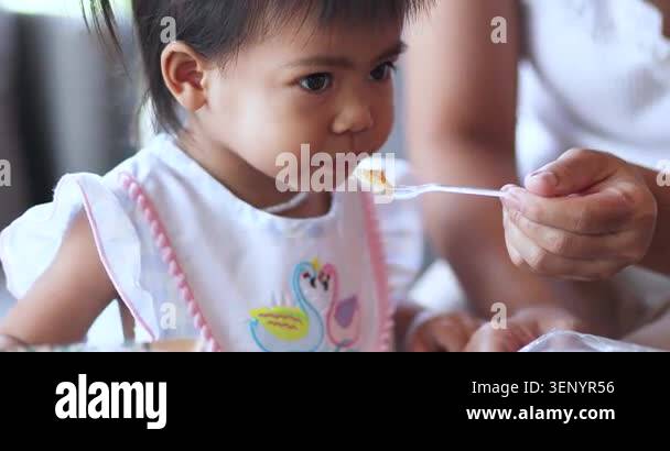Mother feeding snack to her child with love, care, family bonding, and ...