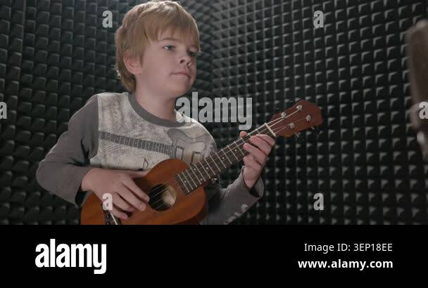 Boy Play Music on Ukulele Instrument in Home Studio. 4K 10-bit Stock ...