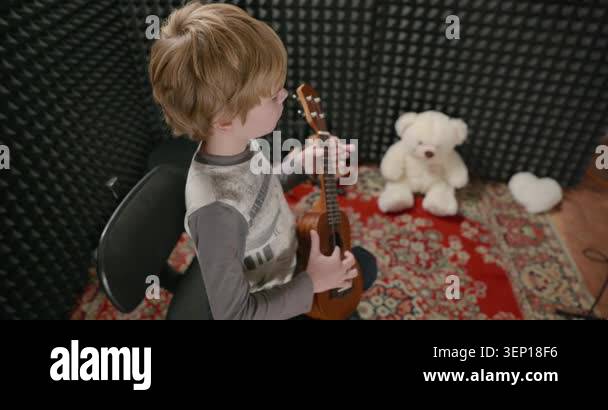 Boy Play Music on Ukulele Instrument in Home Studio. 4K 10-bit Stock ...