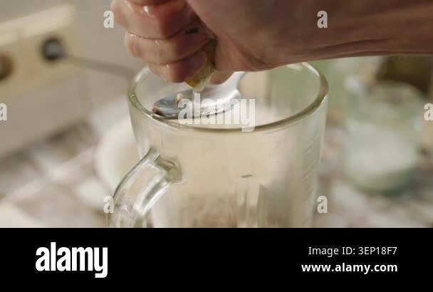 Male hand squeeze lemon juice in blender. Man prepare food cook at ...