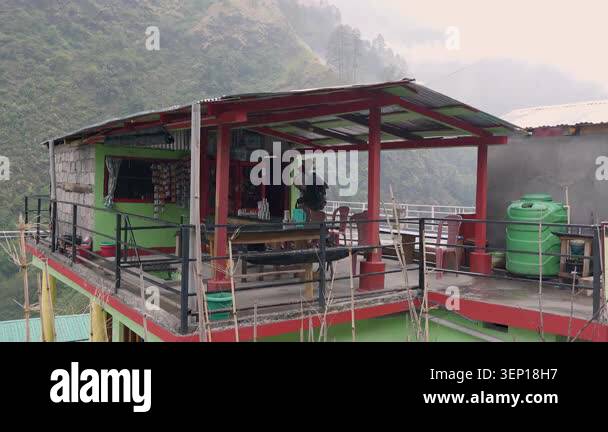 A wooden tea stall on a mountain trail surrounded by dense forests with ...