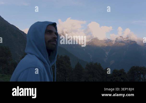 A lone trekker gazes at the majestic Chaukhamba massif shrouded in mist ...