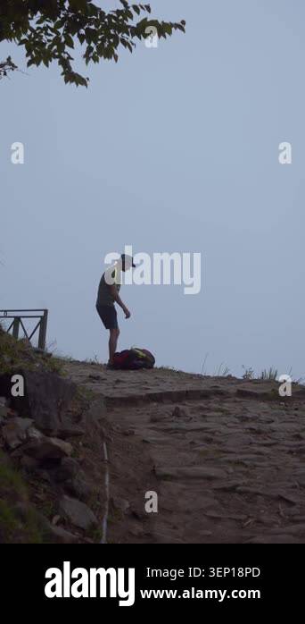 A lone trekker navigates a foggy, rugged path along the Madmaheshwar ...