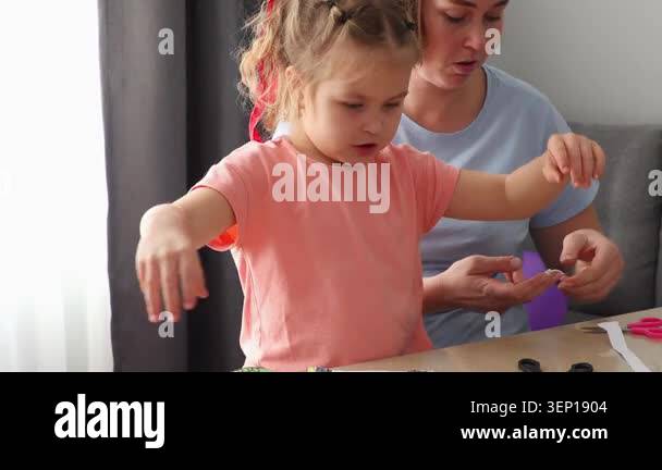 Woman and little Caucasian girl making handmade greeting cards together ...