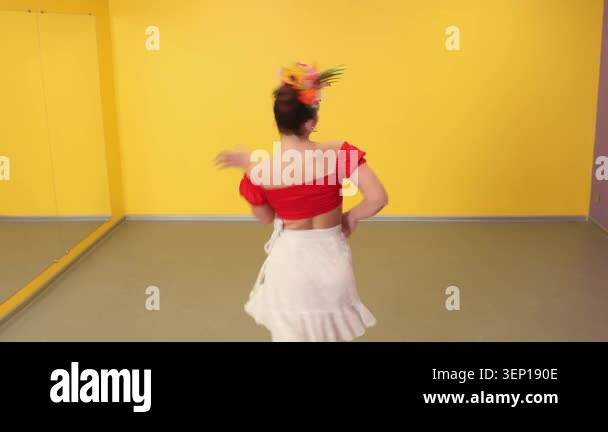 Instructor demonstrates salsa technique to a young female student in ...