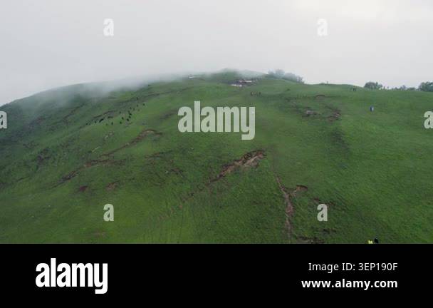 Hikers traverse rolling green hills and dense forests on the ...