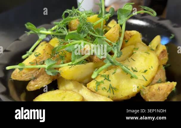 Golden baked or fried country style potato wedges served on black plate ...