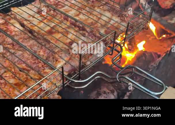 Tender meat ribs cooking on metal grill over glowing coals with smoke ...