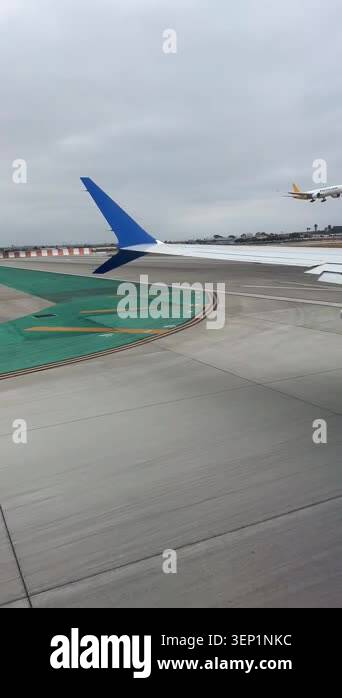 Vertical 4K travel footage showing an airplane taxiing on the runway ...