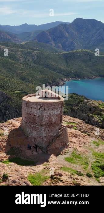 Ancient Genoese tower stands on a rocky cliff overlooking a serene blue ...