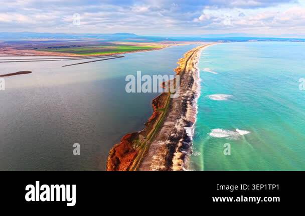 Panoramic aerial view of thin land strip dividing turquoise ocean water ...