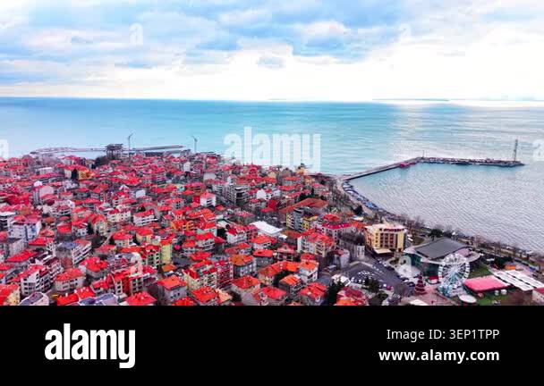 Red roof residential buildings along turquoise waterfront with ...