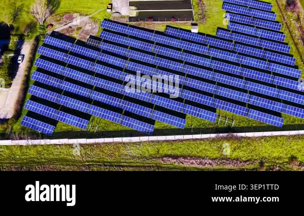 Geen field filled with photovoltaic collectors inside fenced facility ...