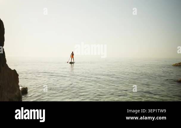 young man in a black dress with a backpack on the background of the sea ...