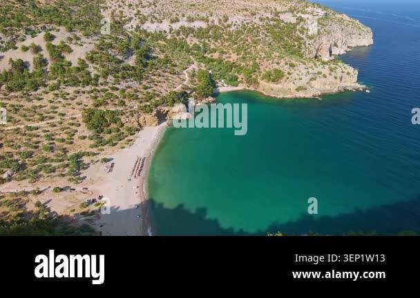 Aerial View of a secluded pebble beach with crystal clear turquoise ...