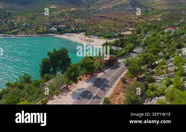 Aerial view of a car on a winding coastal road overlooking the ...
