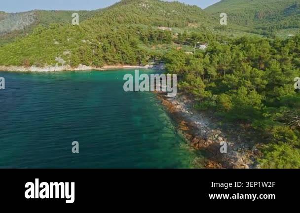 Aerial view of a small secluded bay with emerald water surrounded by ...