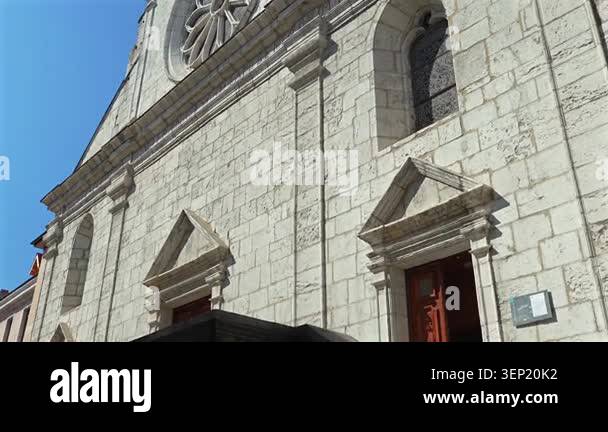 Close upward view of a white stone church facade with rose window in ...