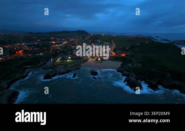 Aerial drone view of a secluded sandy beach and coastal village in ...