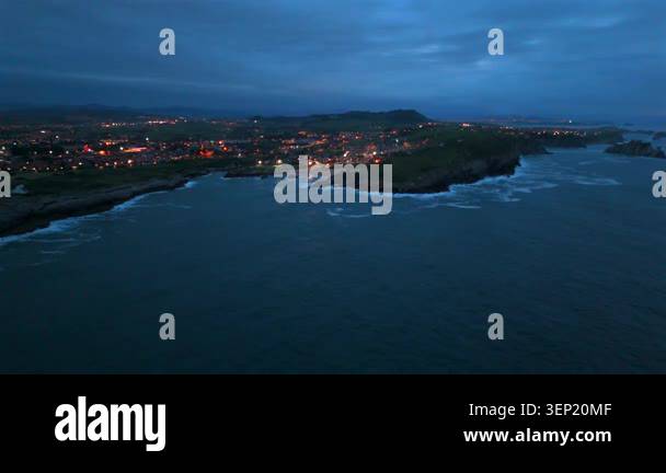 Drone view of rocky peninsula and seaside town at twilight in Santander ...